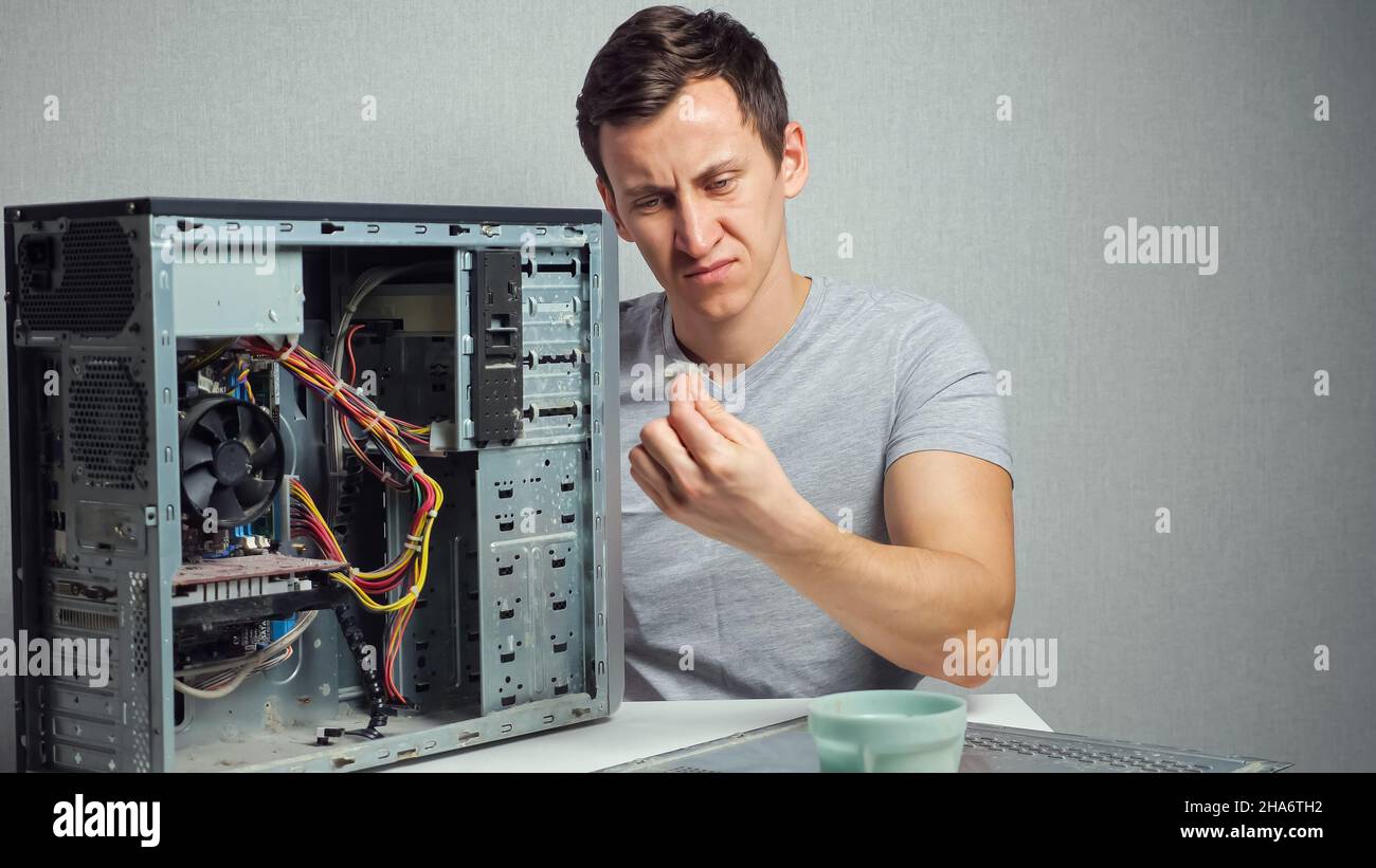 Young man opens a very dusty computer Stock Photo - Alamy