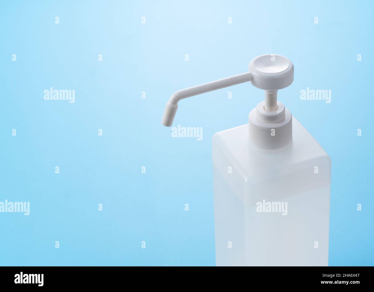 Bottle of alcohol sanitizer spray placed on a blue background in copy ...