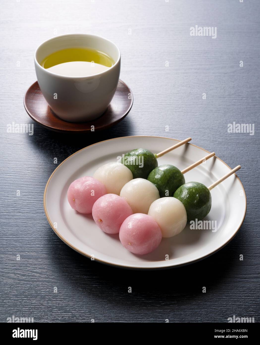 Tricolor dumplings set against a black background. An image of Japanese ...