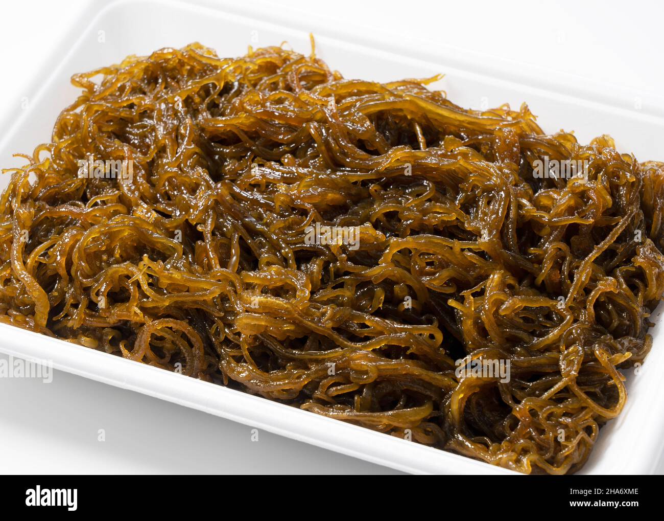 Mozuku in a food tray on a white background.Mozuku is an Okinawan delicacy. It is a kind of dark ...