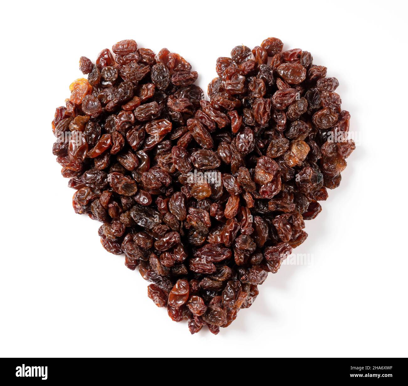 Raisins in the shape of a heart placed on a white background. View from ...