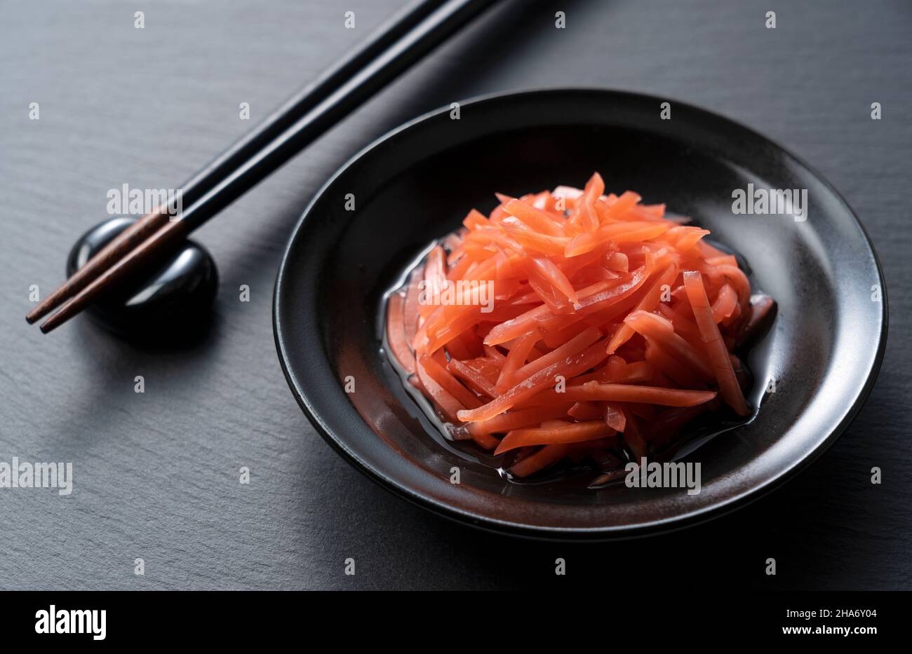 Red pickled ginger placed on a black background. Image of red pickled ...