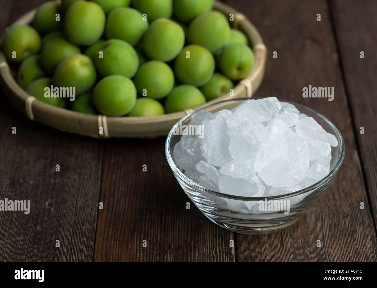 Unripe ume fruit and rock sugar on a wooden background. Preparing to ...