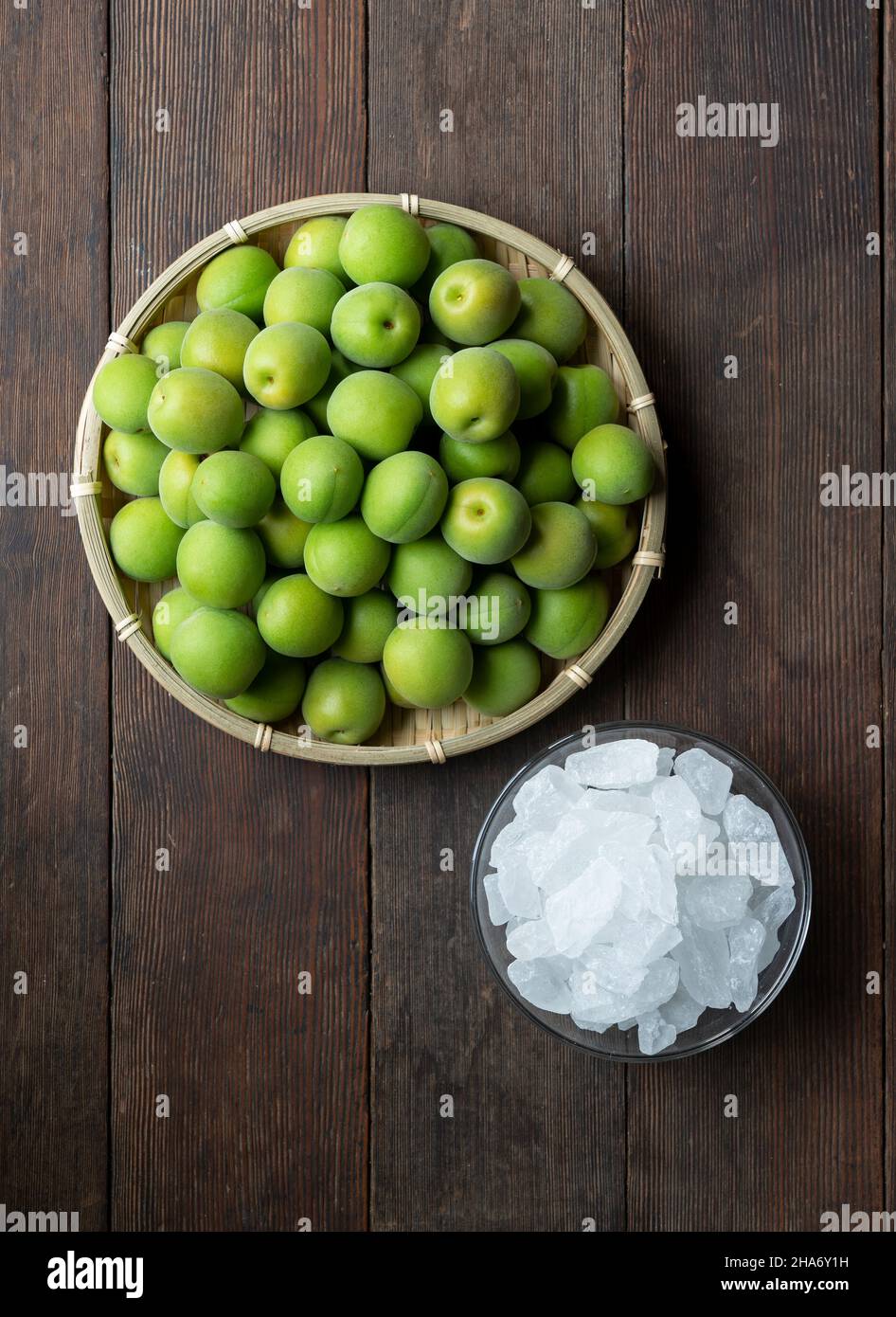 Unripe ume fruit and rock sugar on a wooden background. Preparing to ...