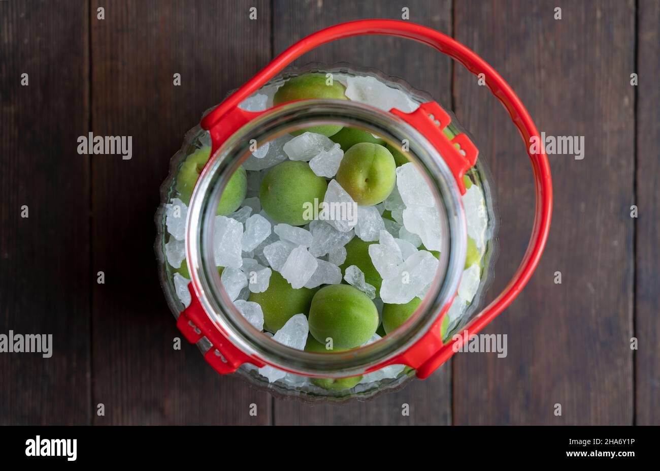 Unripe ume fruit and rock sugar on a wooden background.Making ...
