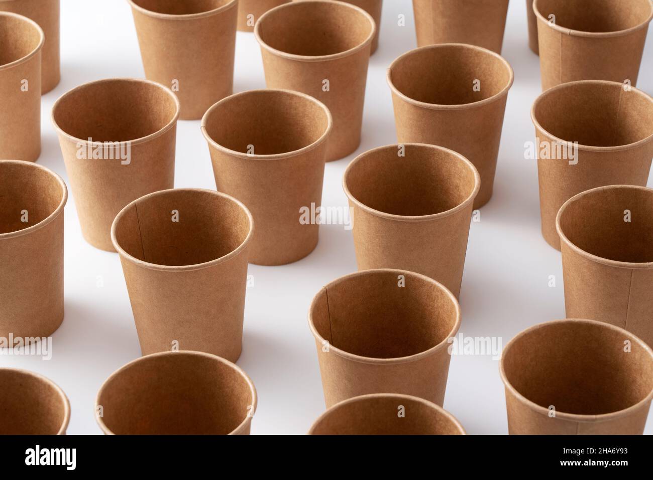 A lot of brown recycled paper cups on a white background. The zero ...