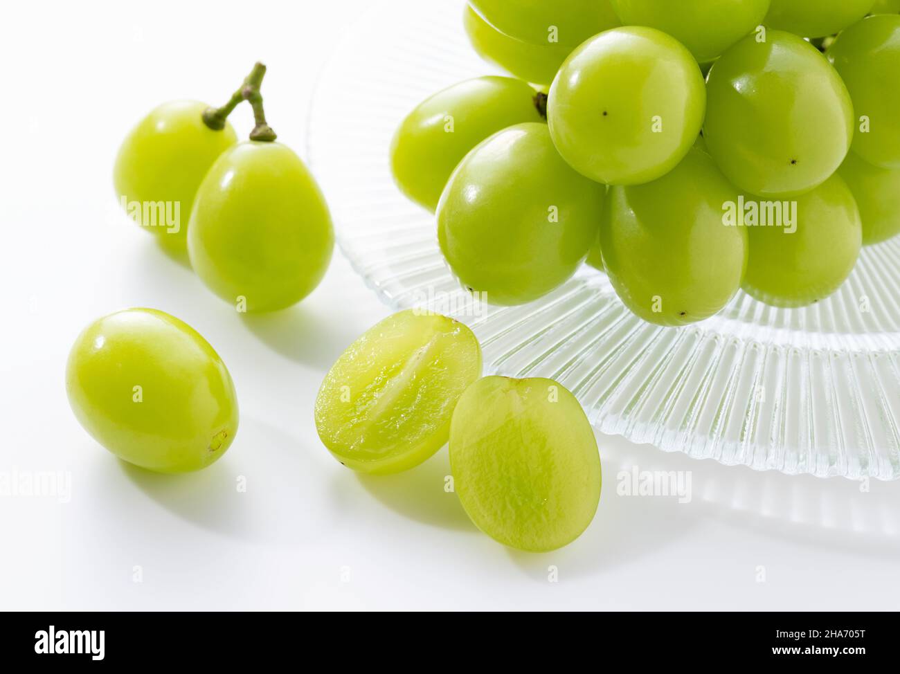 A lot of Shine-Muscat grapes and cut Shine-Muscat grapes on a white ...