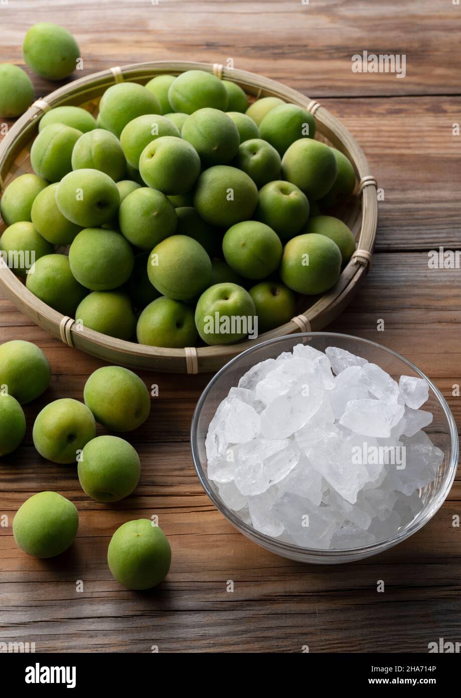 Unripe ume fruit and rock sugar on a wooden background. Preparing to ...
