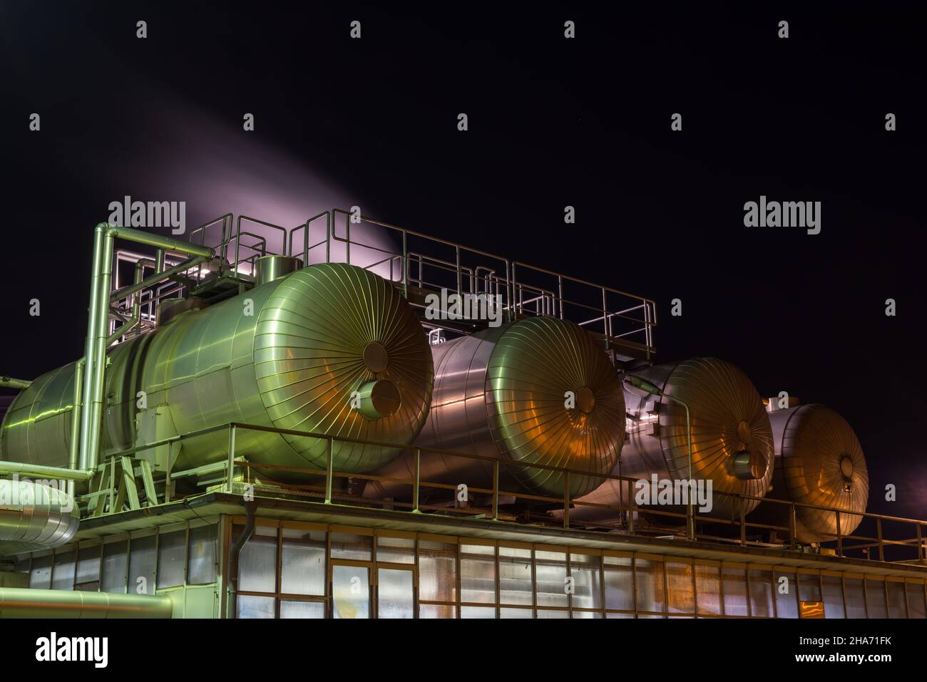 Four stainless steel storage tanks at night Stock Photo - Alamy