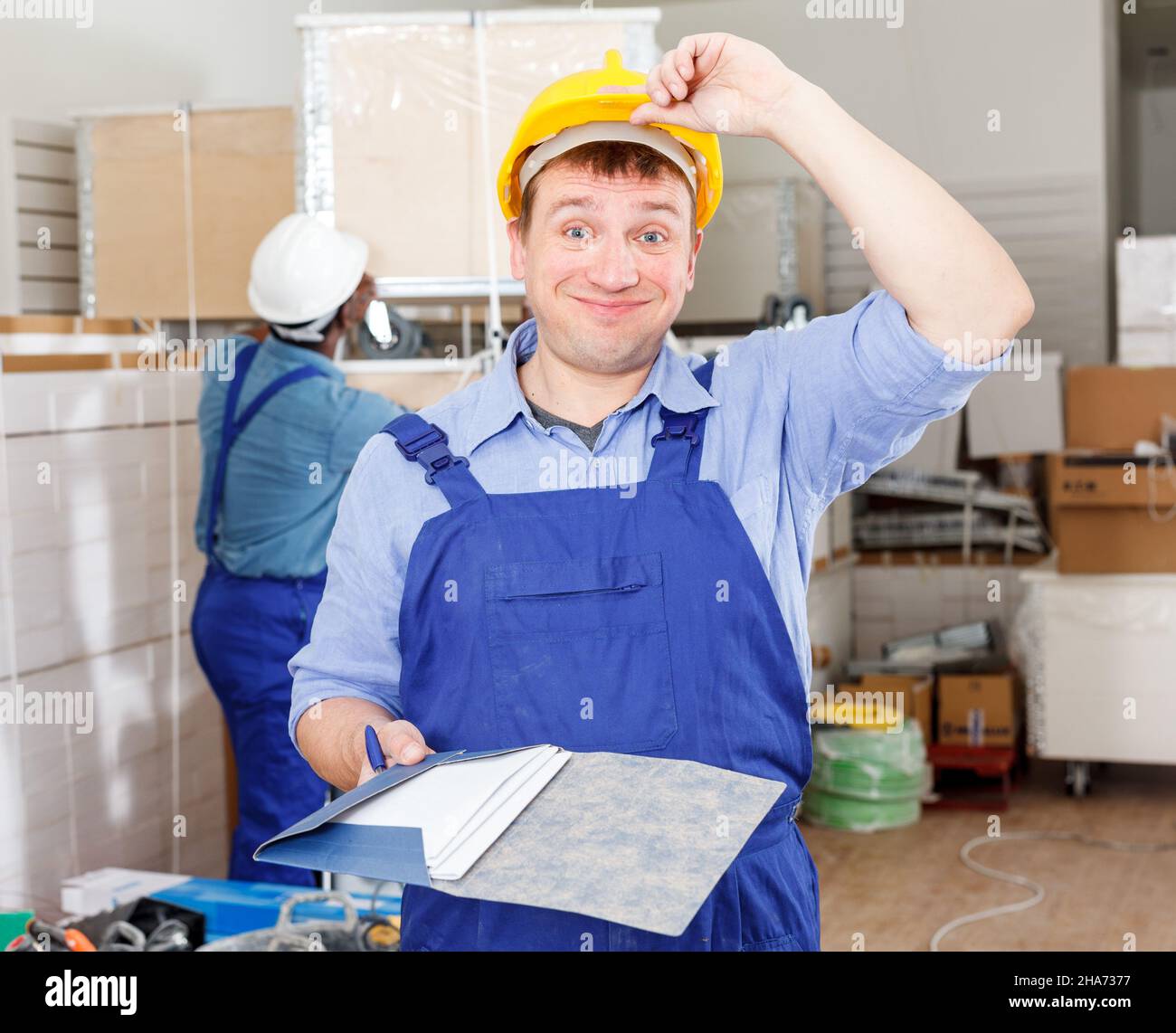 Puzzled builder handyman examining room while planning renovation works ...