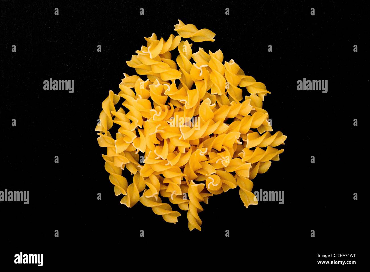 A Heap of Uncooked Fusilli Pasta Scattered on Black Table. Raw and Dry ...