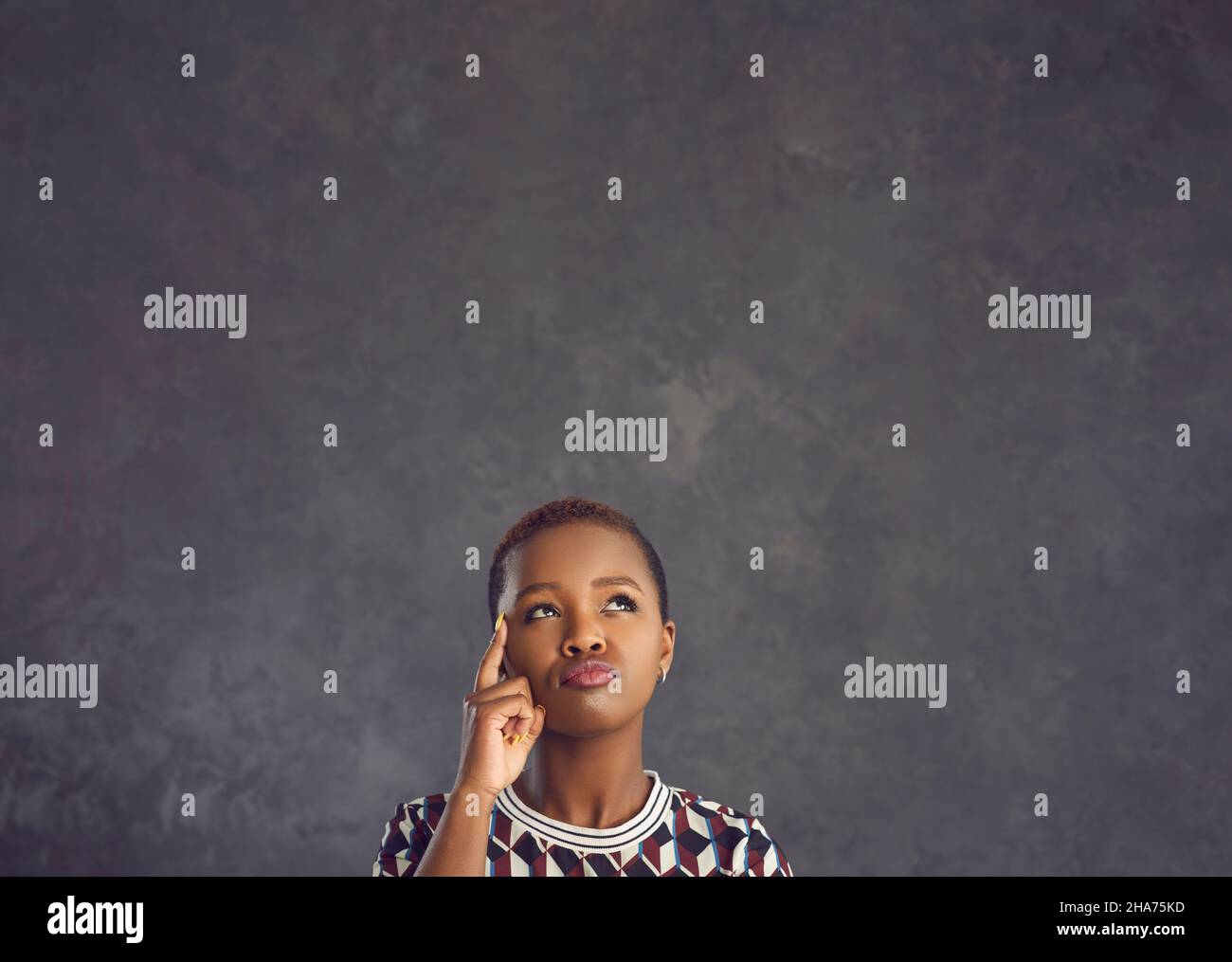 Confused black woman looking up, thinking, making choice, doubting ...