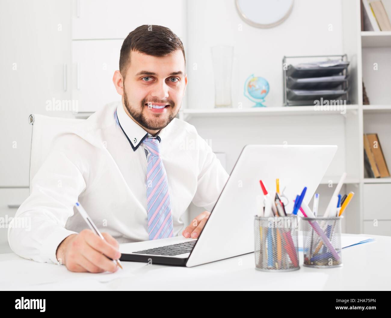 Positive male manager working effectively on project in office Stock ...