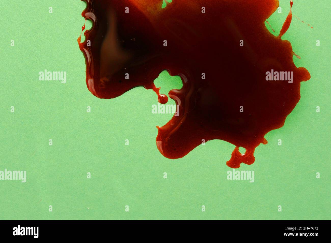 pool of red blood on green background Stock Photo - Alamy