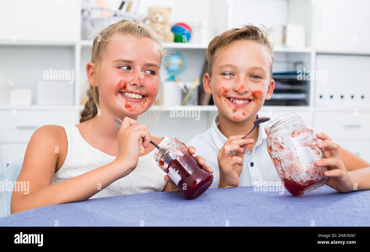 Portrait of sister with brother who are eating jam at time lunch at ...