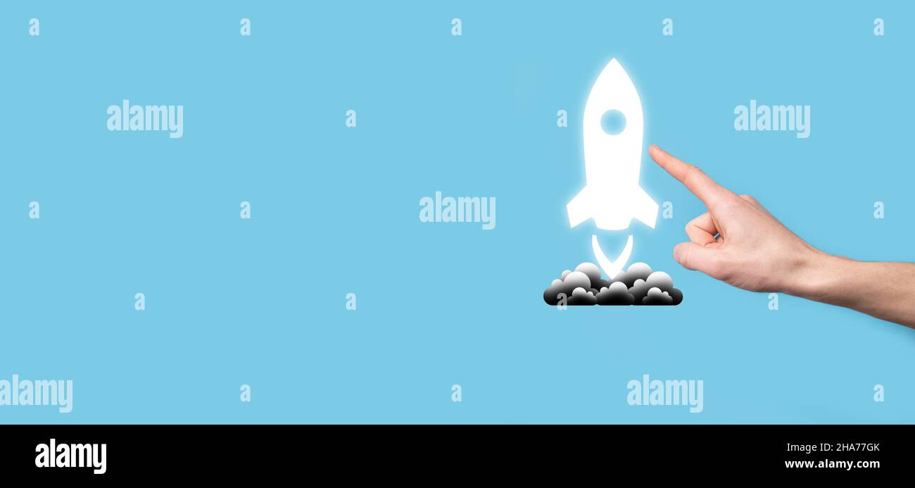 Male hand holding rocket icon that takes off, launch on blue background ...