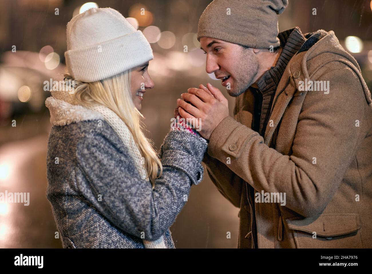 cold snowy night.Romantic smiling man and woman outdoors in winter ...