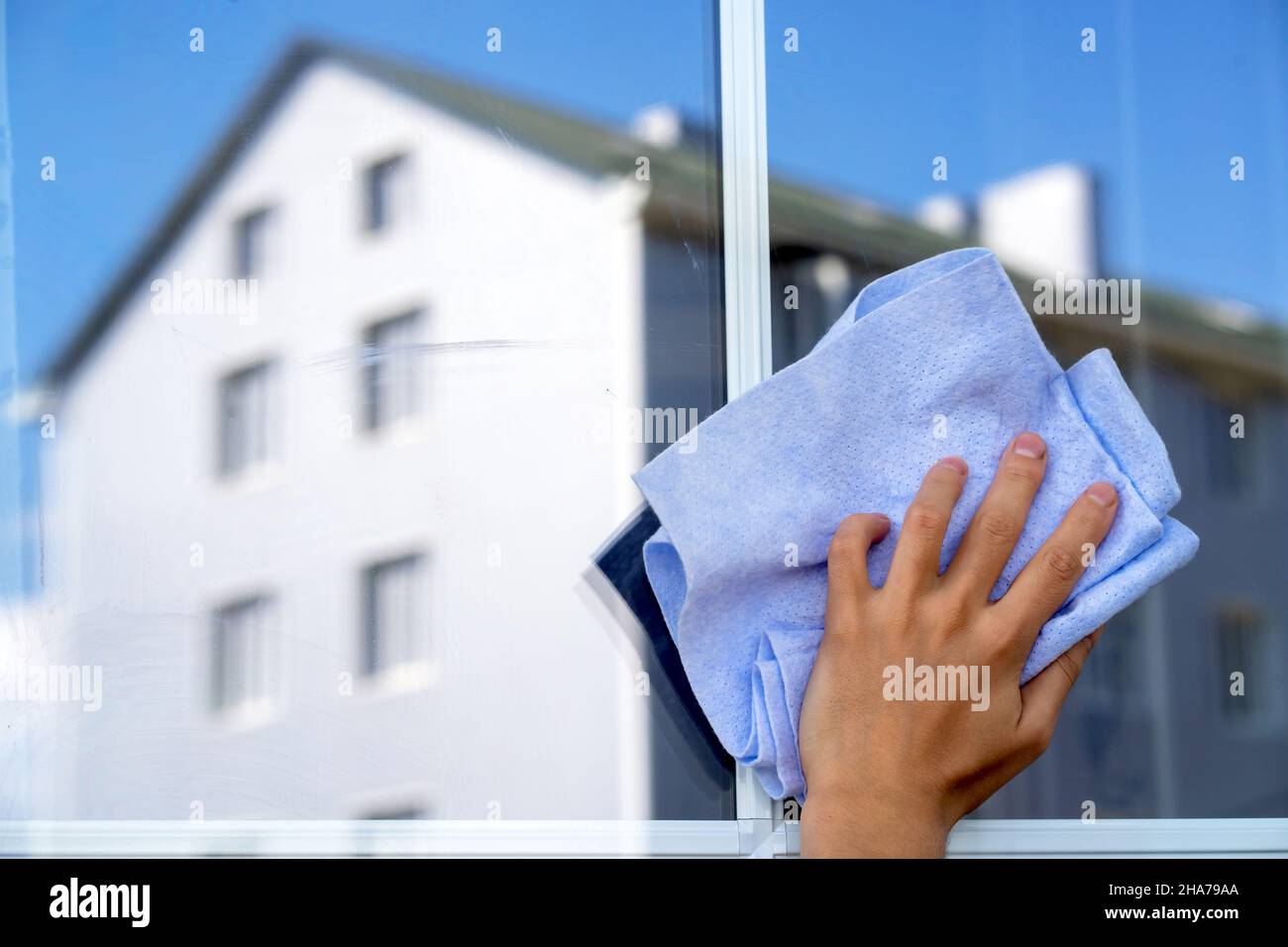 Housekeeper is cleaning the window with a rag Stock Photo - Alamy