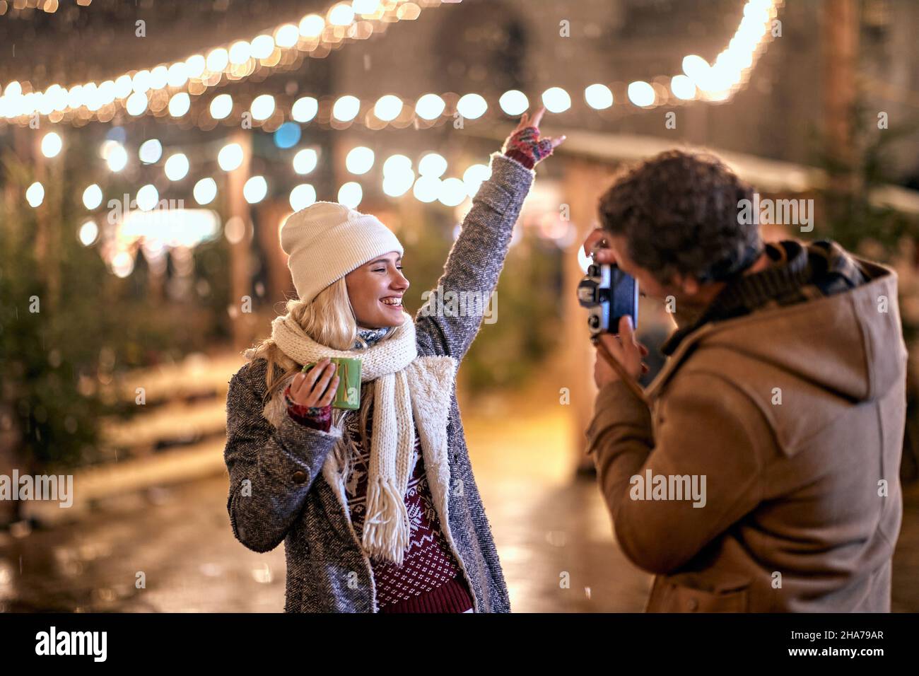 Happy girl enjoying at christmas festival on a snowy weather and man ...
