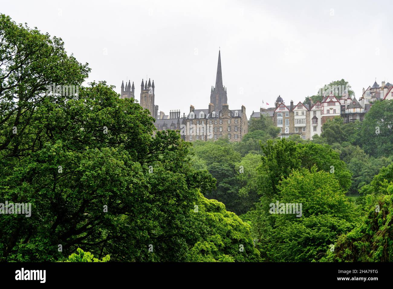 Row of old historic buildings behind large green trees in Edinburgh ...
