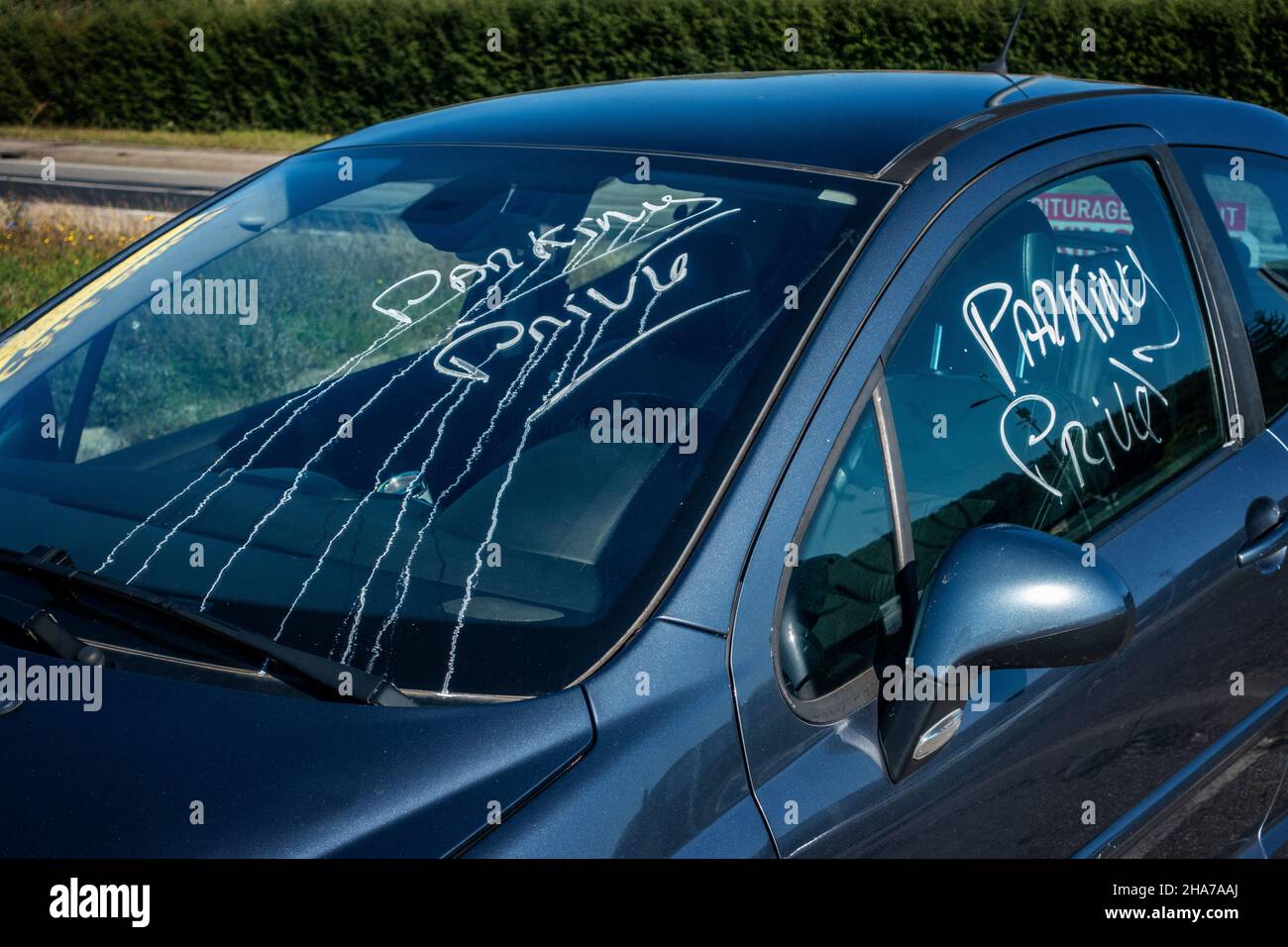 Bad Parking warning sign, written on a illegally parked car in France ...