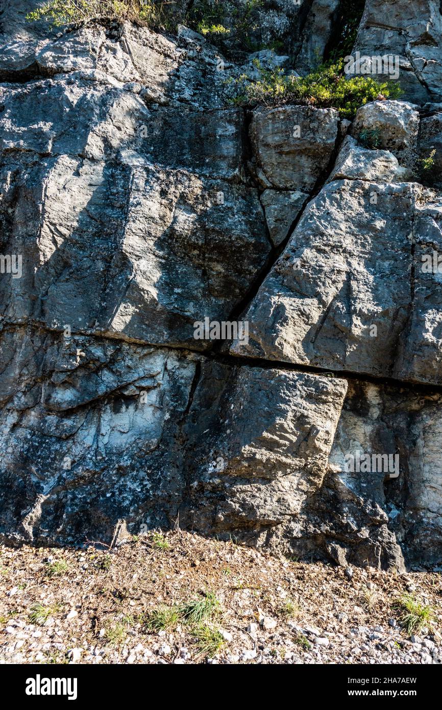 man-made stone wall built into cliff rock face Stock Photo - Alamy
