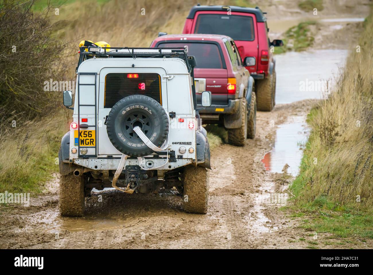 4x4 off-road vehicles driving across mud and water-logged terrain ...