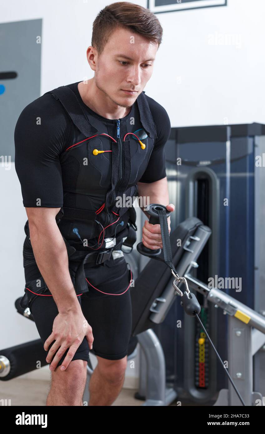 Young man performing full-body electric muscle stimulation training in ...