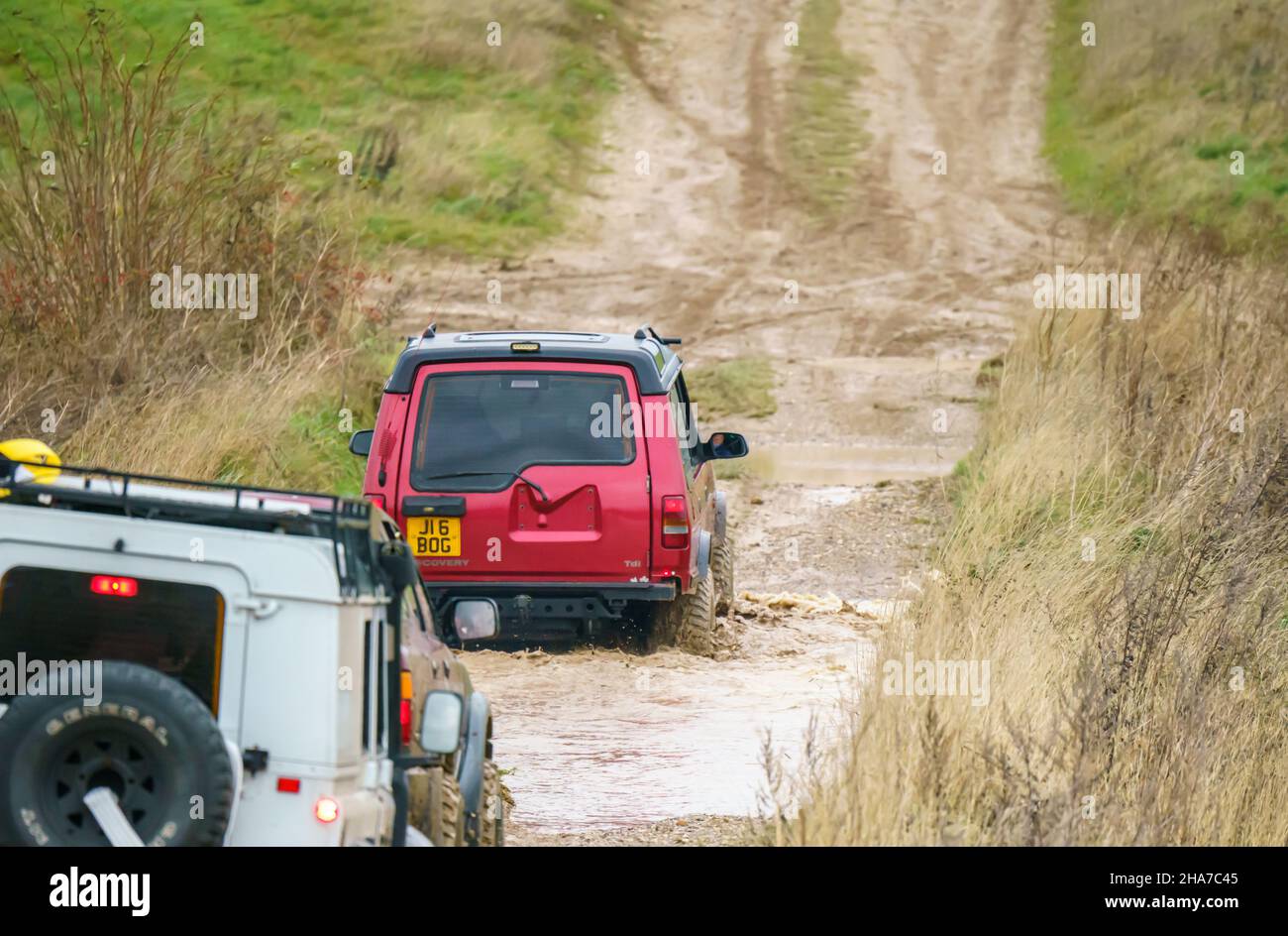 4x4 off-road vehicles driving across mud and water-logged terrain ...