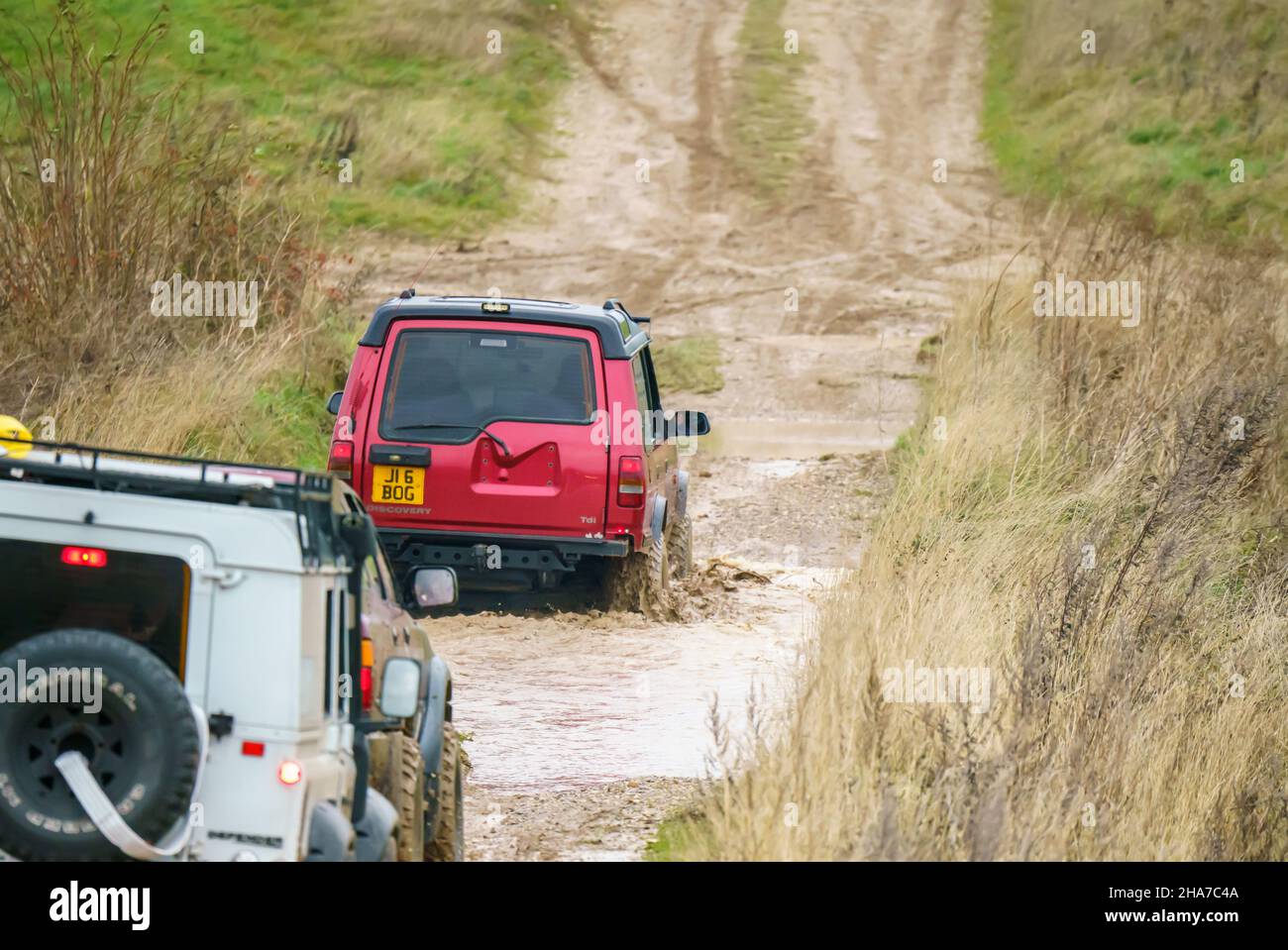 4x4 off-road vehicles driving across mud and water-logged terrain ...