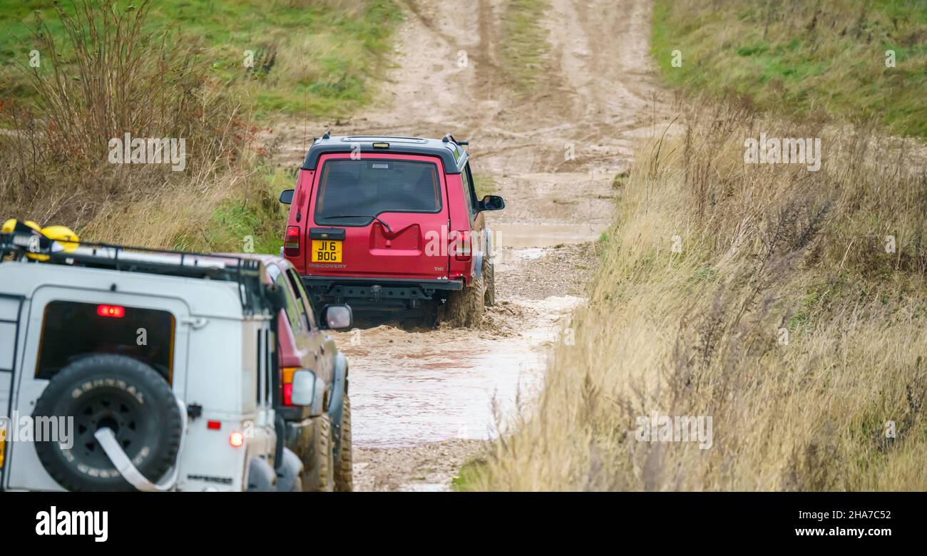4x4 off-road vehicles driving across mud and water-logged terrain ...