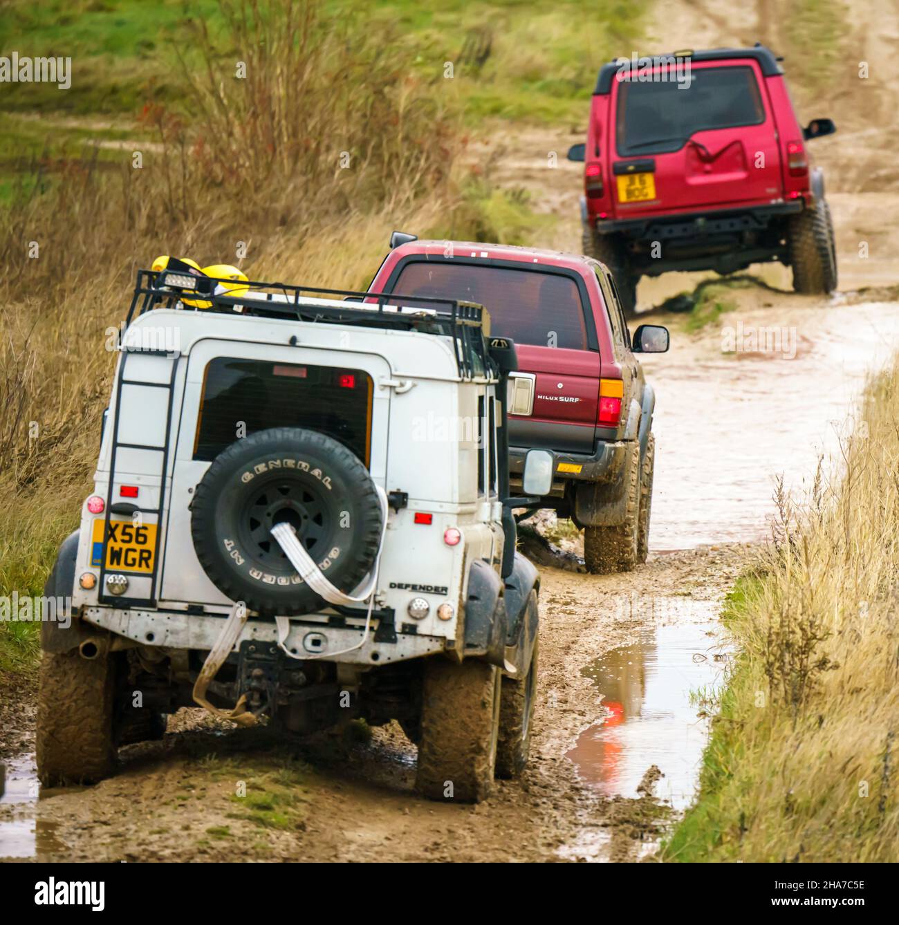 4x4 off-road vehicles driving across mud and water-logged terrain ...