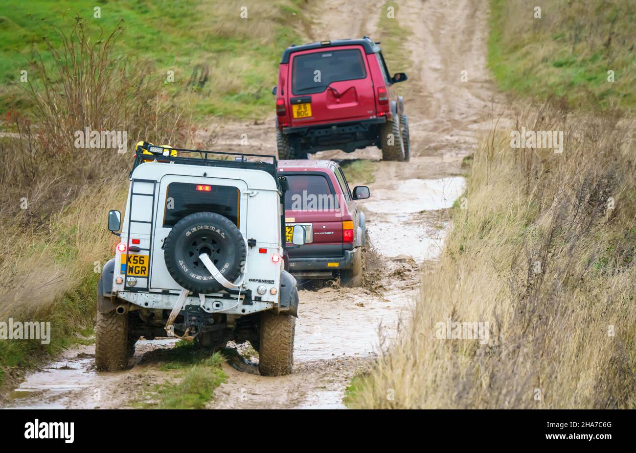 4x4 off-road vehicles driving across mud and water-logged terrain ...