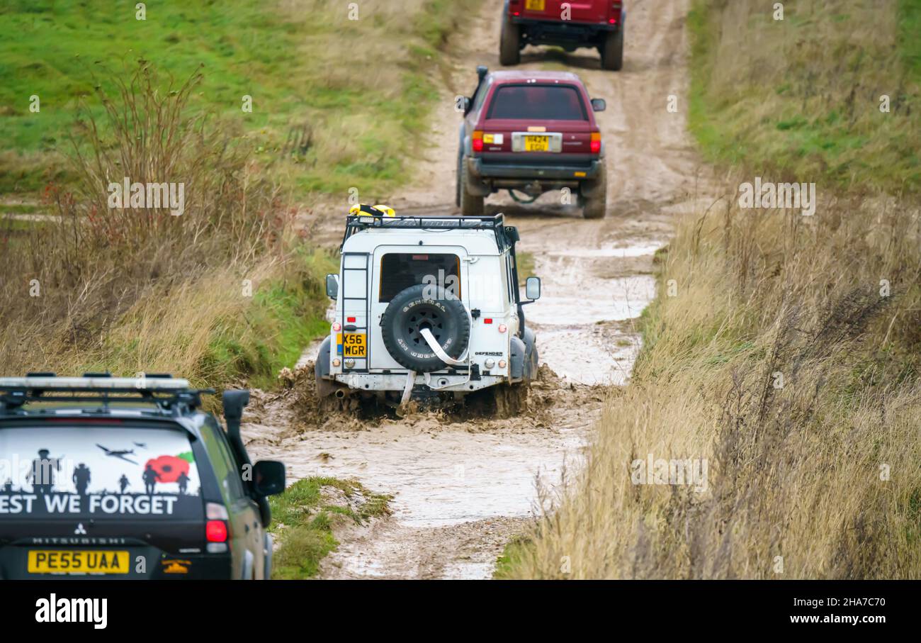 4x4 off-road vehicles driving across mud and water-logged terrain ...