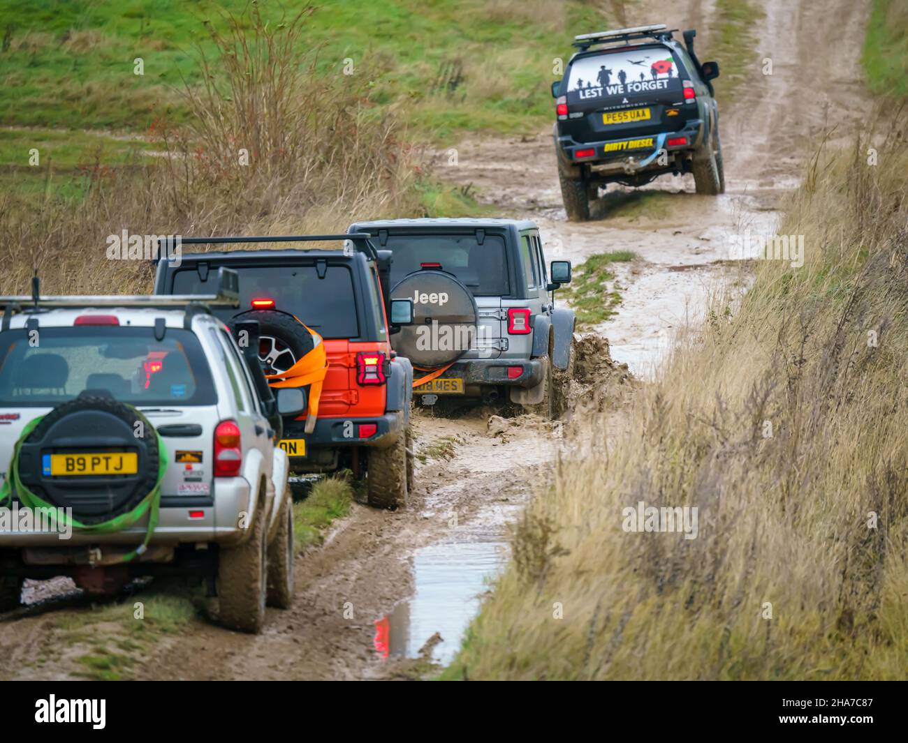 4x4 off-road vehicles driving across mud and water-logged terrain ...