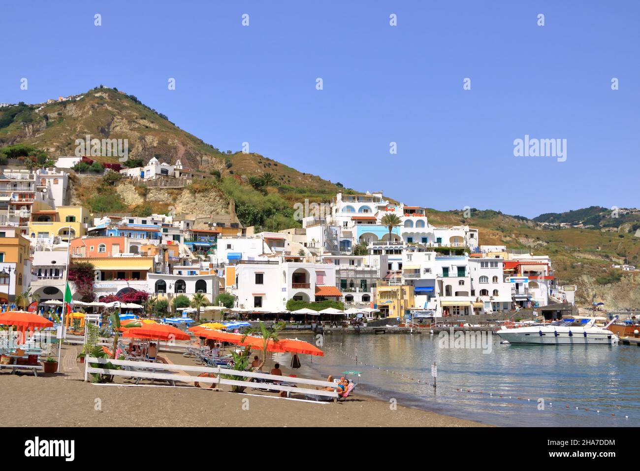 July 12 2021 - Sant Angelo, Ischia, Italy: Beach with umbrellas, port ...