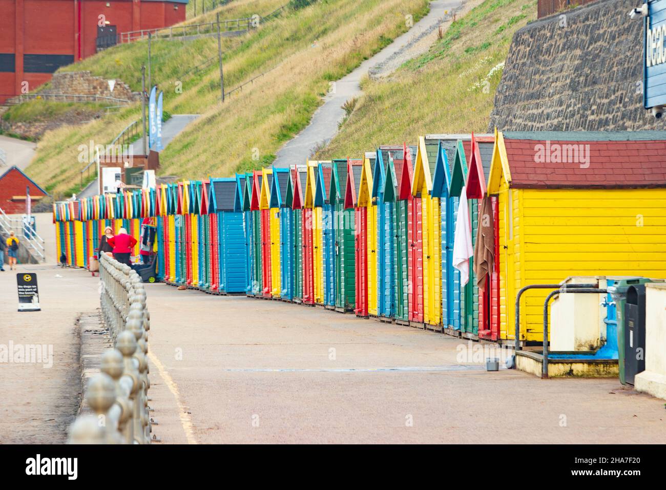 colourful row or line of beach huts chalets on the seafront promenade ...