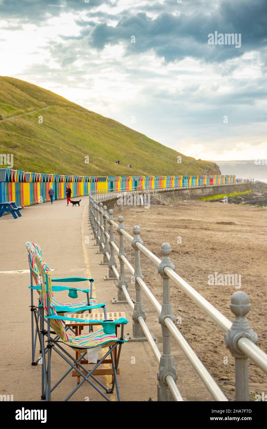 colourful row or line of beach huts chalets on the seafront promenade ...