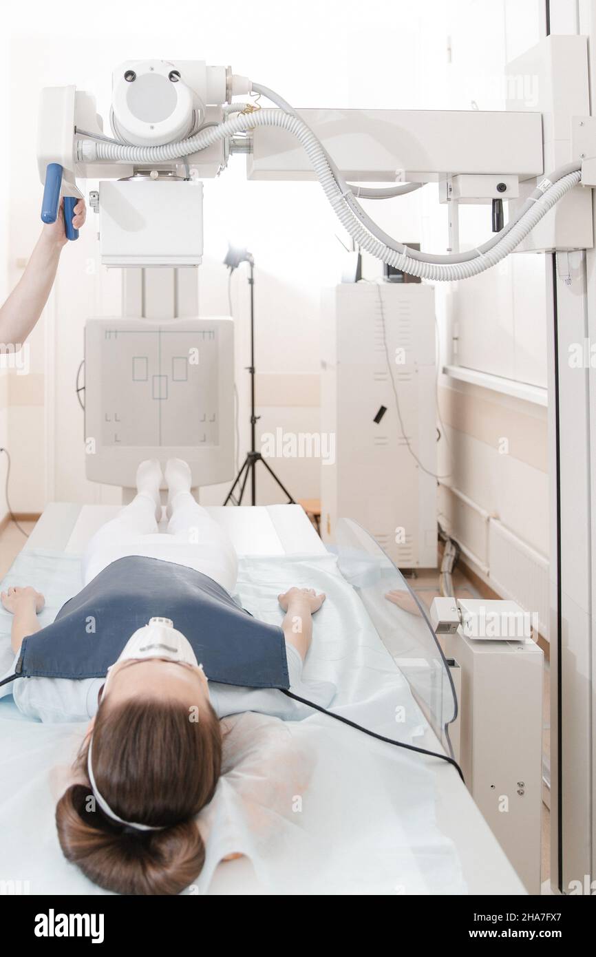 Doctor taking x-ray of patient lying on gurney. Hospital radiology room ...