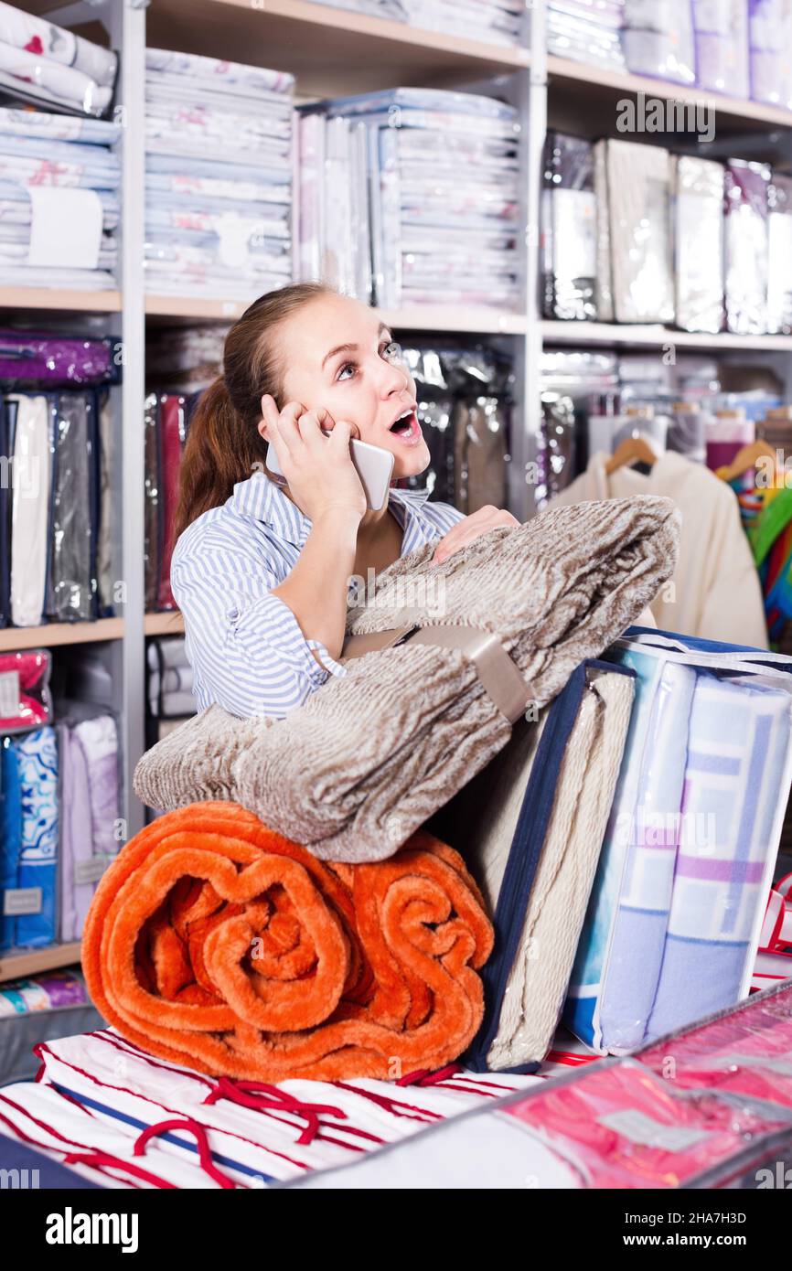 Young woman customer buying multiple items in textile shop Stock Photo ...