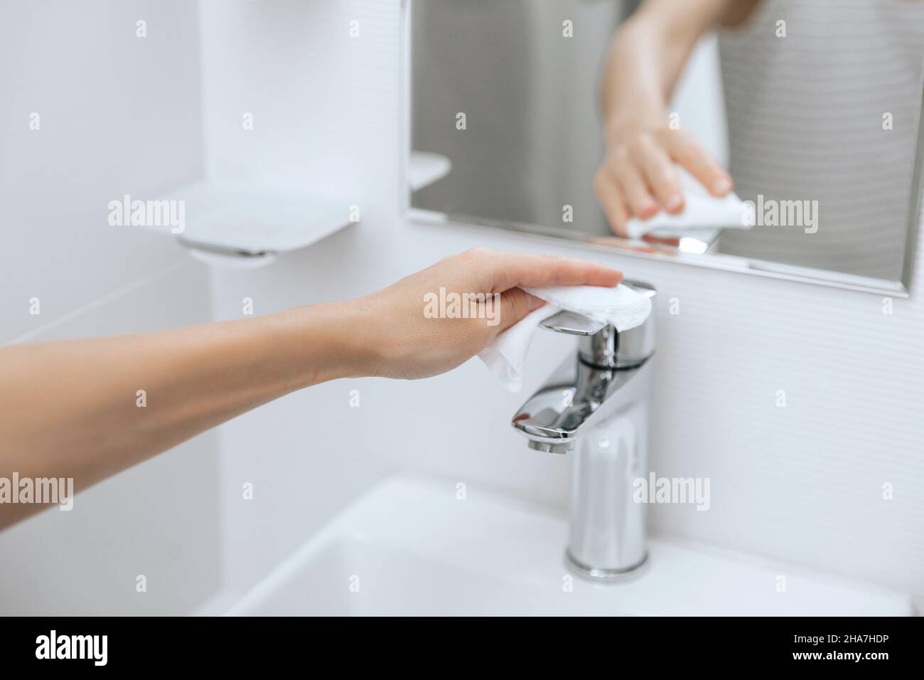Cleaning the sink faucet with a microfiber cloth. Sanitize surfaces ...