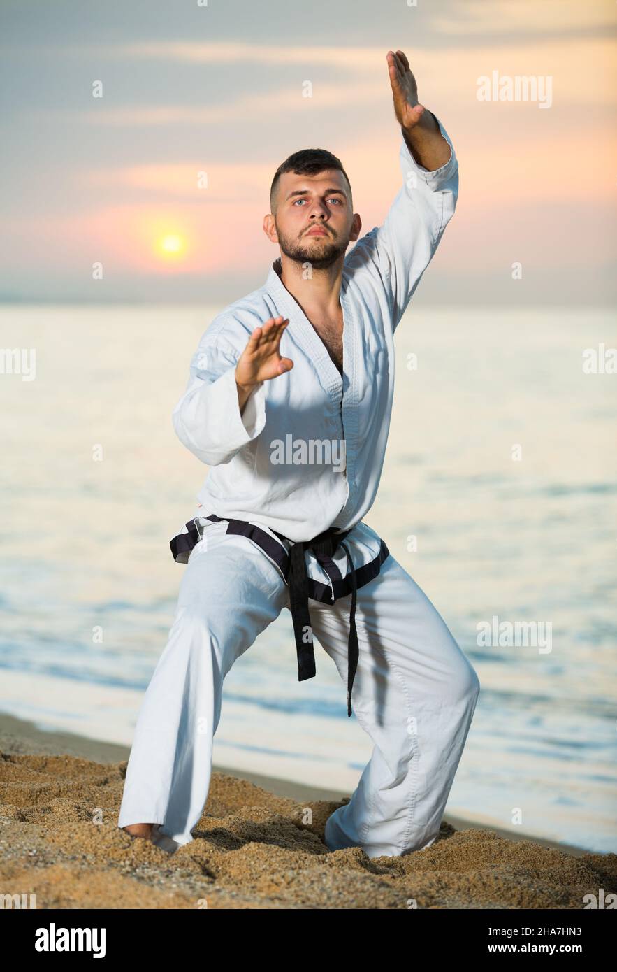 Smiling male doing karate at ocean quay outdoor Stock Photo - Alamy