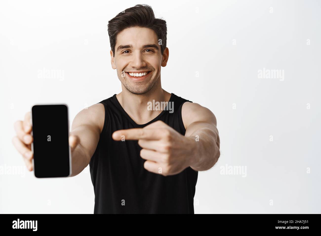 Male athlete workout with smartphone app, pointing and showing phone ...
