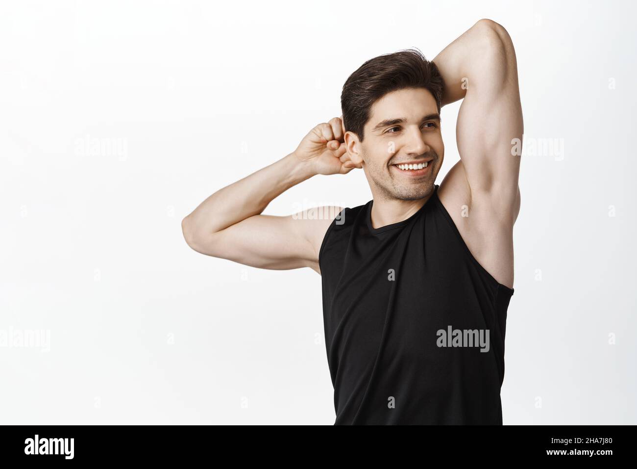 Strong and handsome man with biceps, masculine body, stretching arms ...