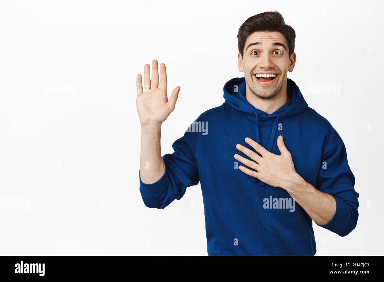 Smiling excited man raising hand up and pointing at himself ...