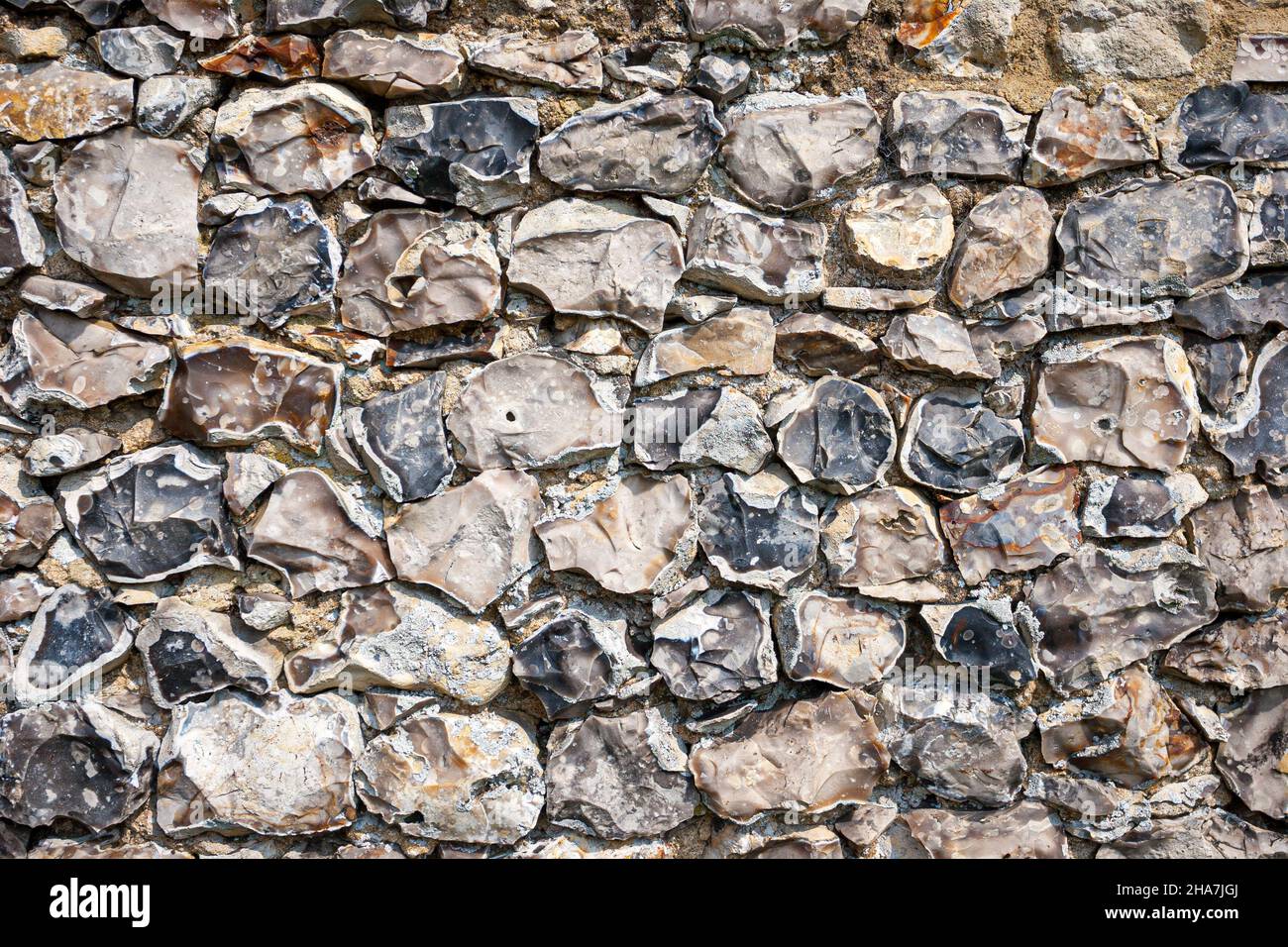 Wall faced with napped flints set in mortar to provide an attractive ...