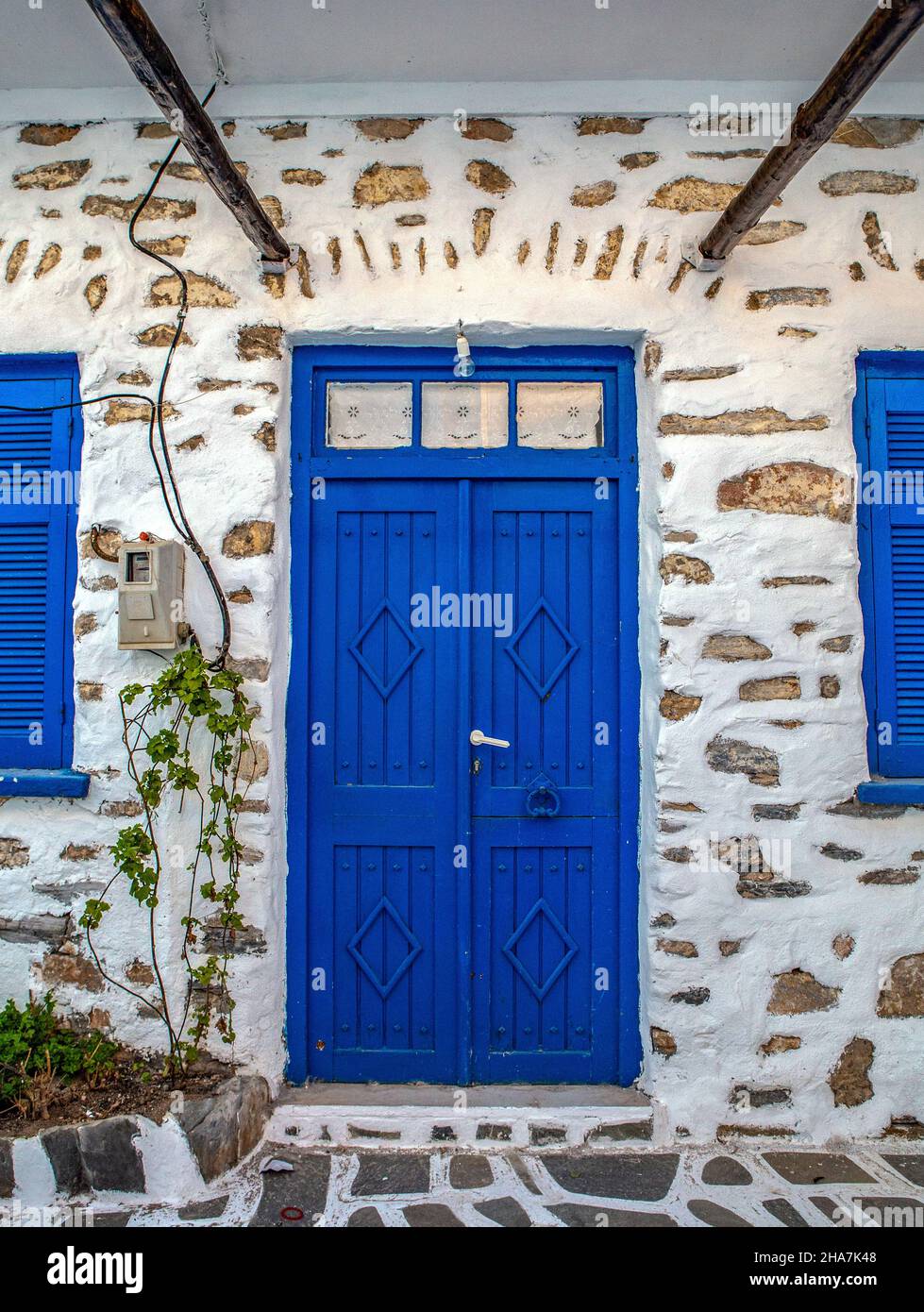 blue door and windows of a traditional Greek house at Cyclades islands ...