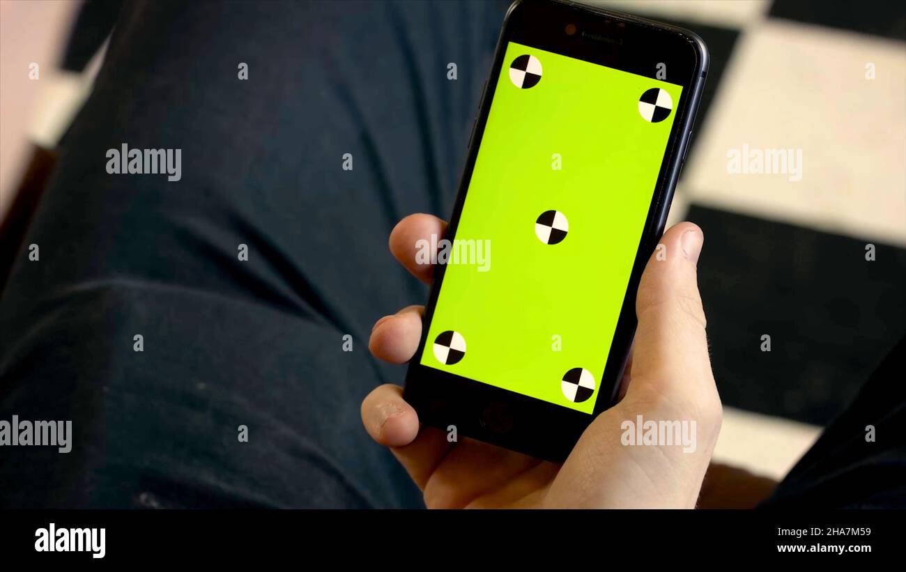 Close-up of man holding phone with green screen. Stock footage. Man ...