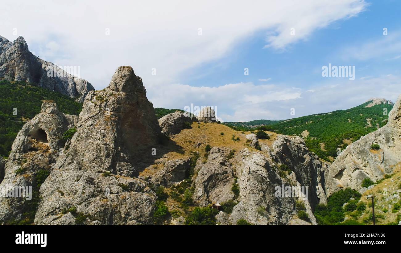 Top view of rock ridges on the background of green mountains and blue ...