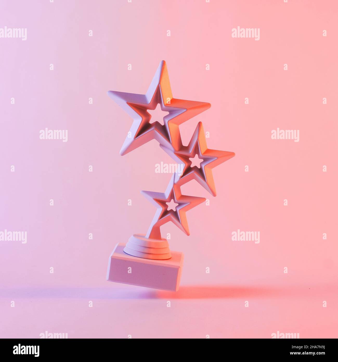 Award with three star shapes floating with shadow against pink ...